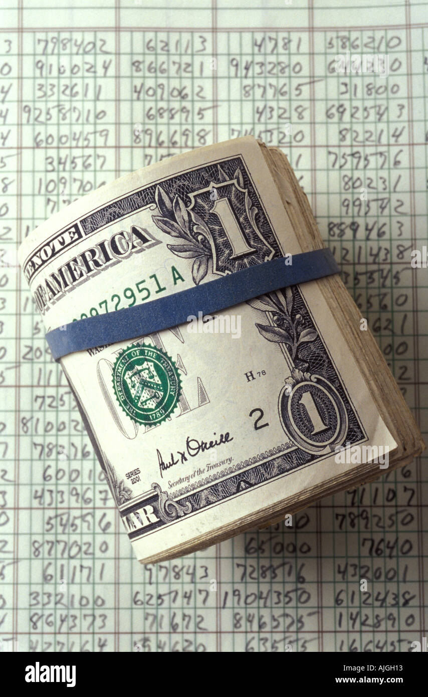 Cash roll of dollar bills on accounting records Stock Photo - Alamy