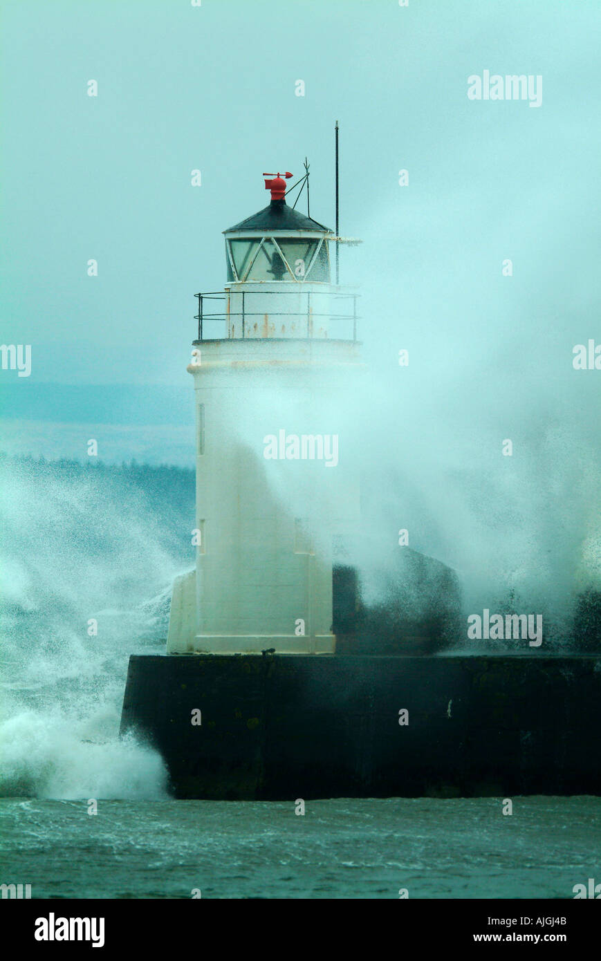 Waves crashing over lighthouse during storm Stock Photo - Alamy