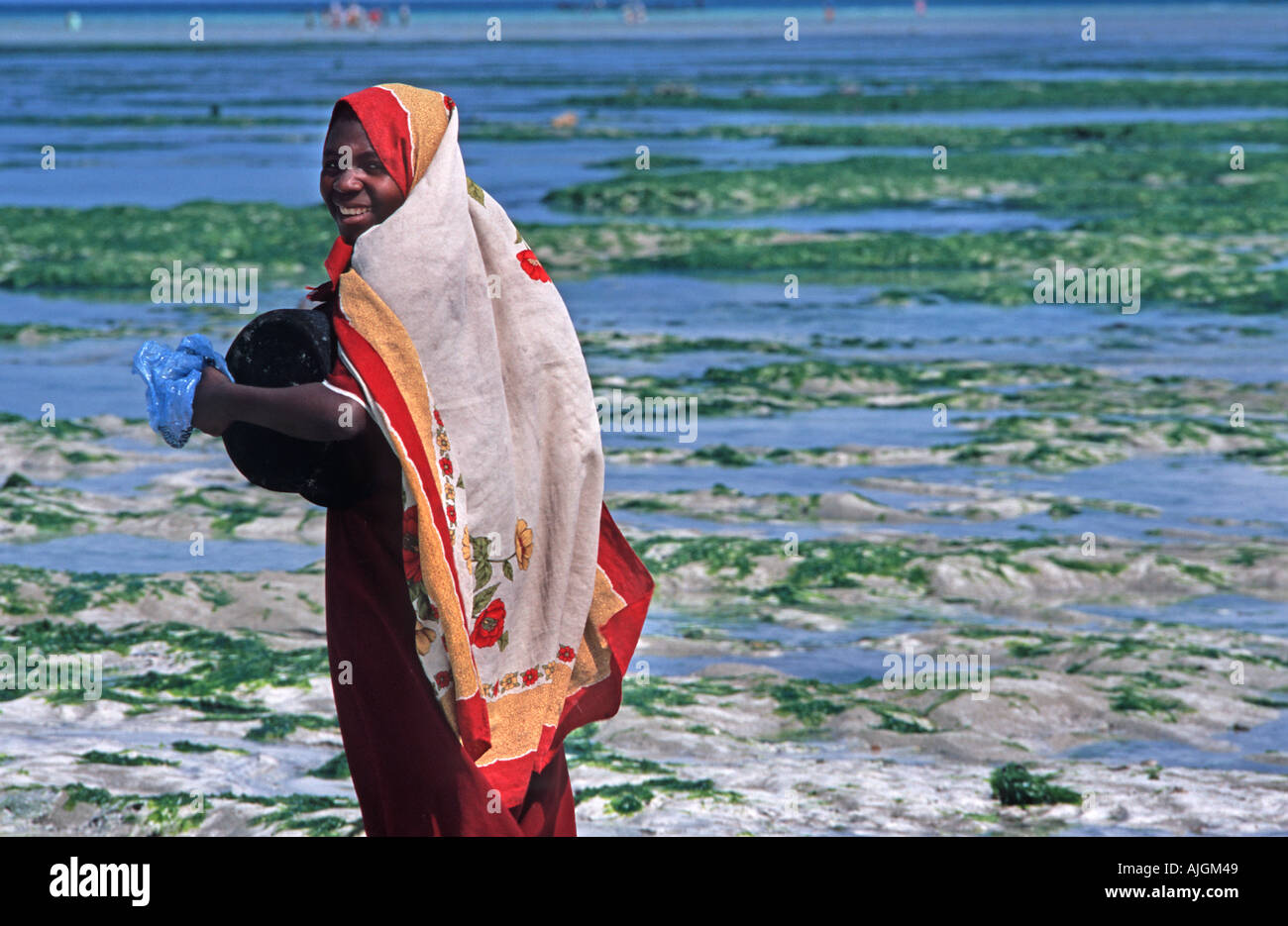 Zanzibari woman in a colouful kanga cloth turns and smiles Nungwi ...