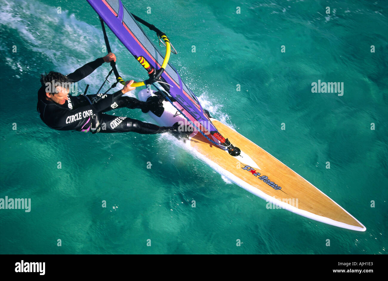 aerial view of windsurfer on sailing a wood effect board on clear ...