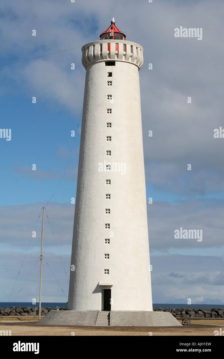 A big white lighthouse by the shore of the ocean Stock Photo - Alamy