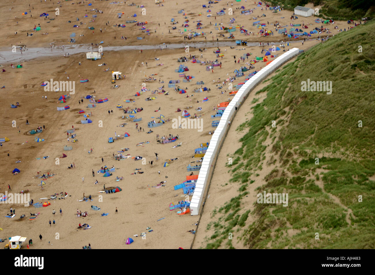 Aerial view of busy summer beach and beach huts at Woolacombe in Devon ...