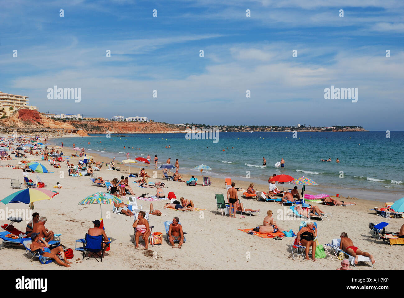PEOPLE SUNBATHING ON BEACH AT PLAYA DE LA GLEA CAMPOAMOR NR TORREVIEJA ...