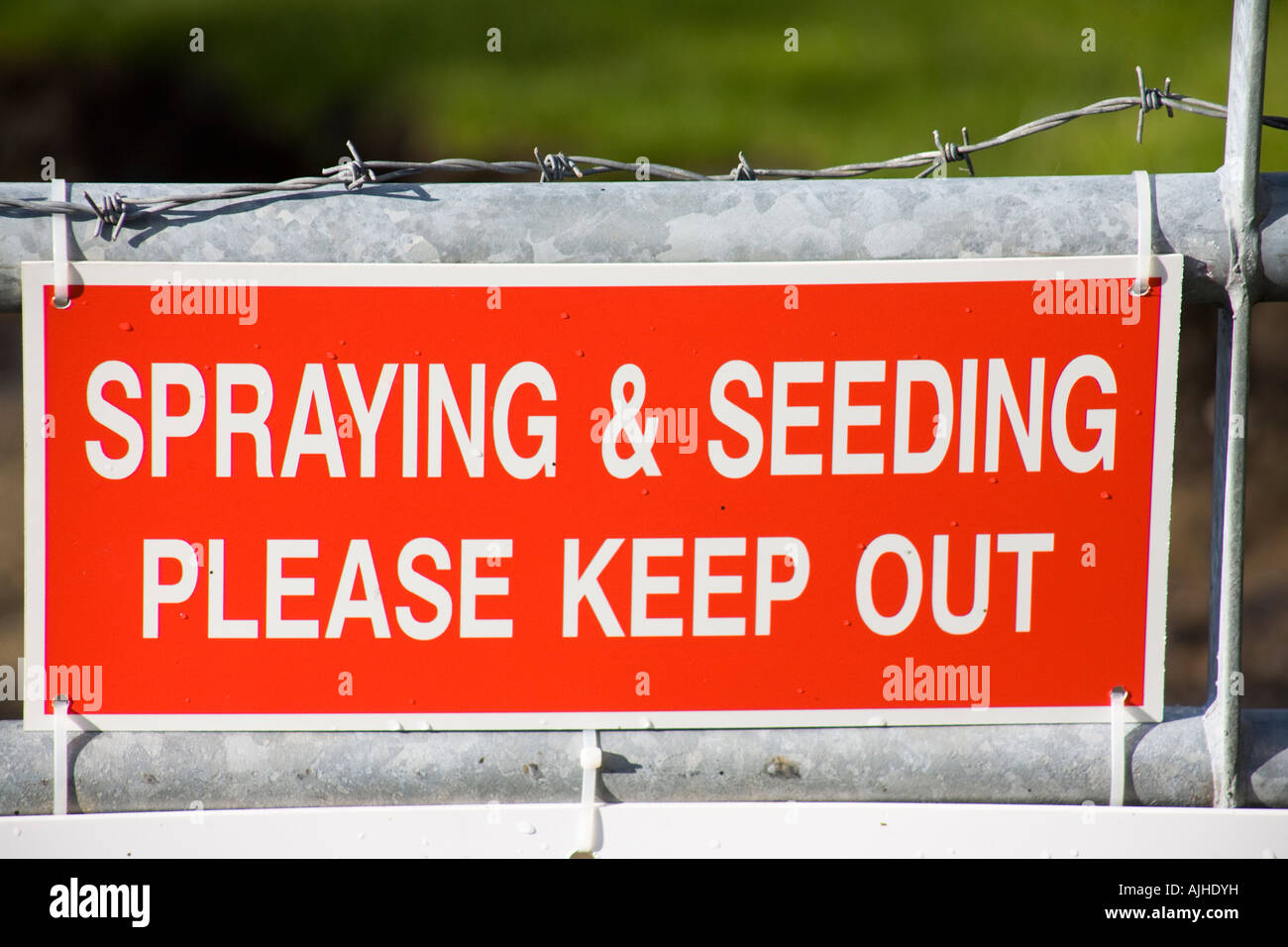 Sign saying SPRAYING AND SEEDING PLEASE KEEP OUT Stock Photo - Alamy