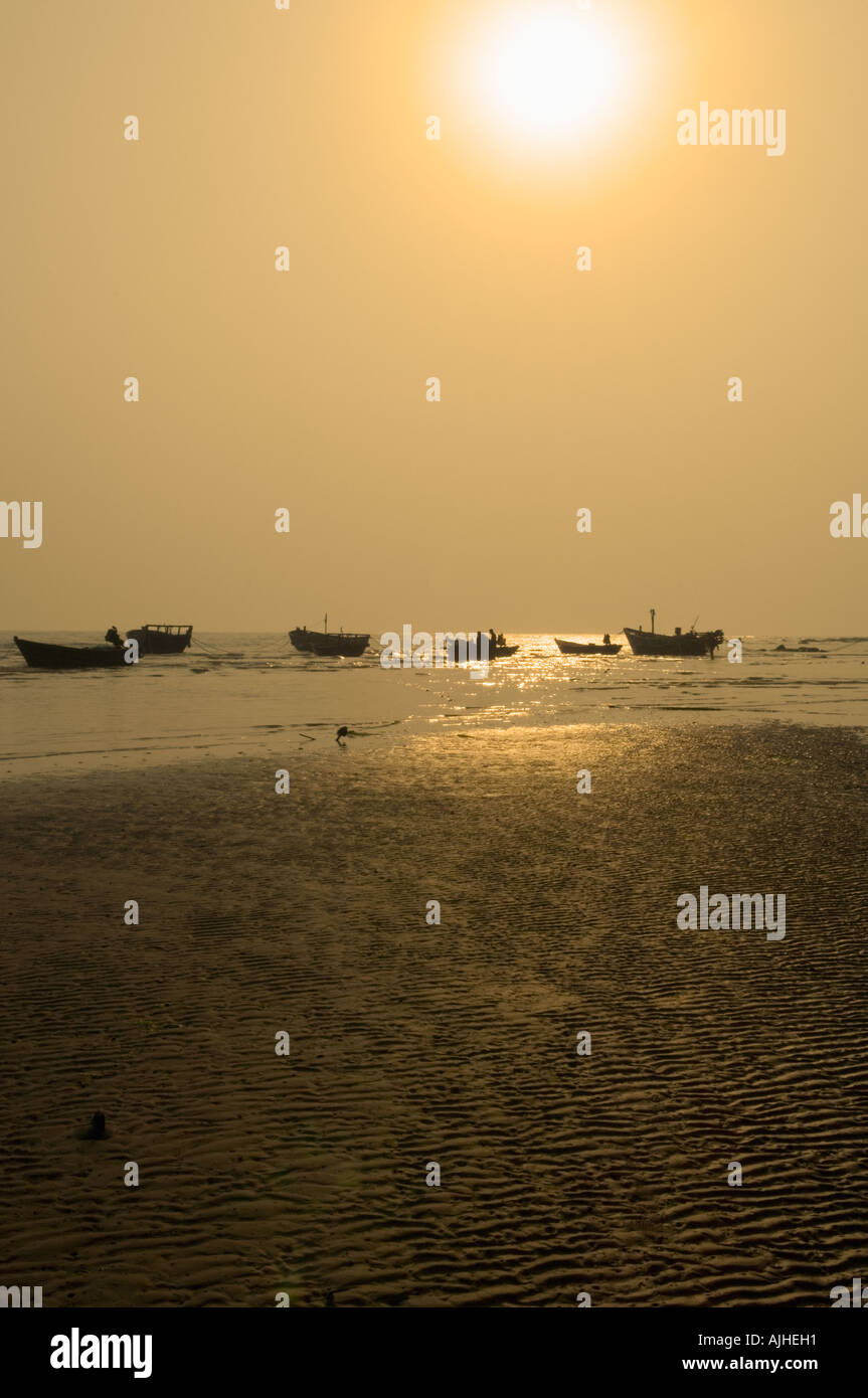 Beidaihe beach on Bo Hai Sea with fishing boats at sunrise in Hebei ...