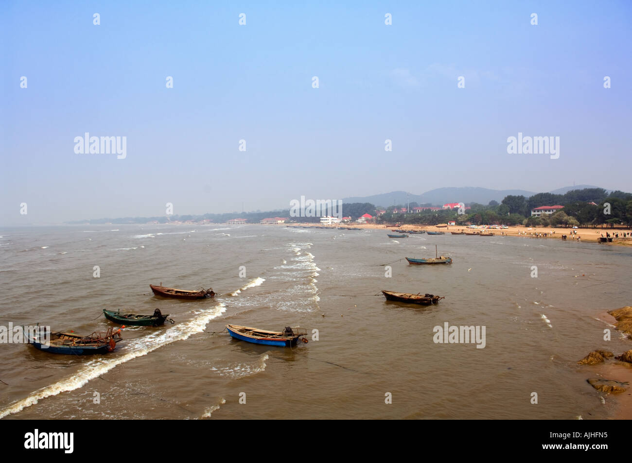 Beidaihe beach on Bo Hai Sea with fishing boats at sunrise in Hebei ...