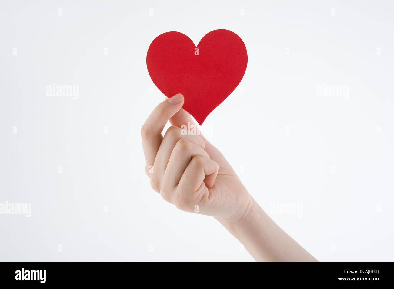 Woman's hand holding heart-shaped paper Stock Photo - Alamy