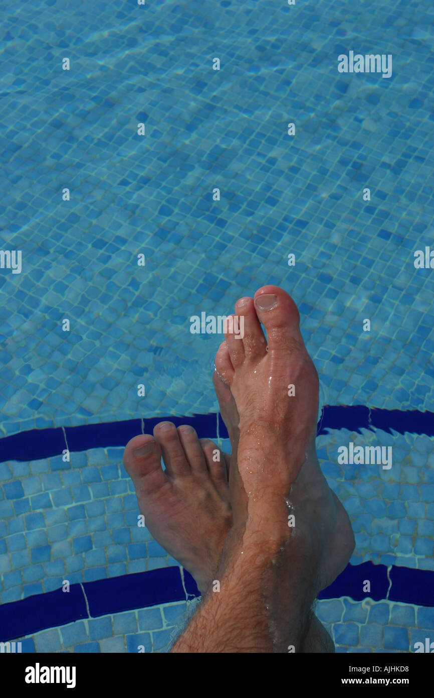 Relaxation male feet dipping in outdoor swimming pool Stock Photo - Alamy