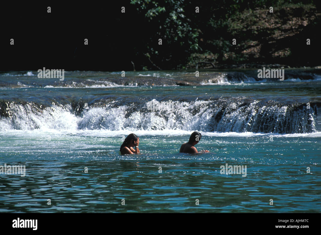 Belize couple standing swimming in river beside waterfalls rapids ...