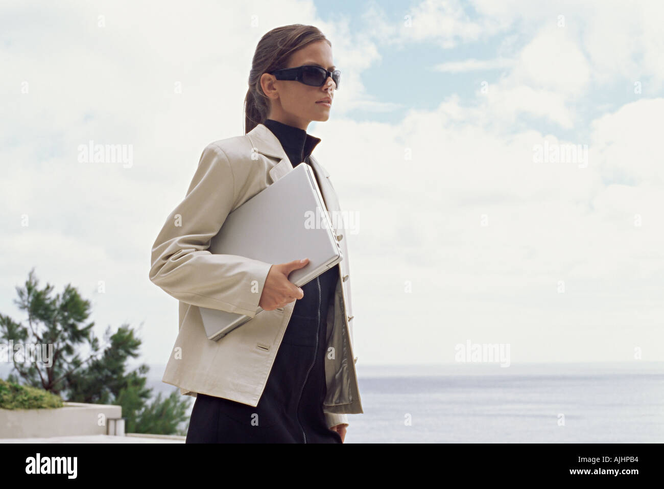 Stylish woman carrying laptop Stock Photo - Alamy