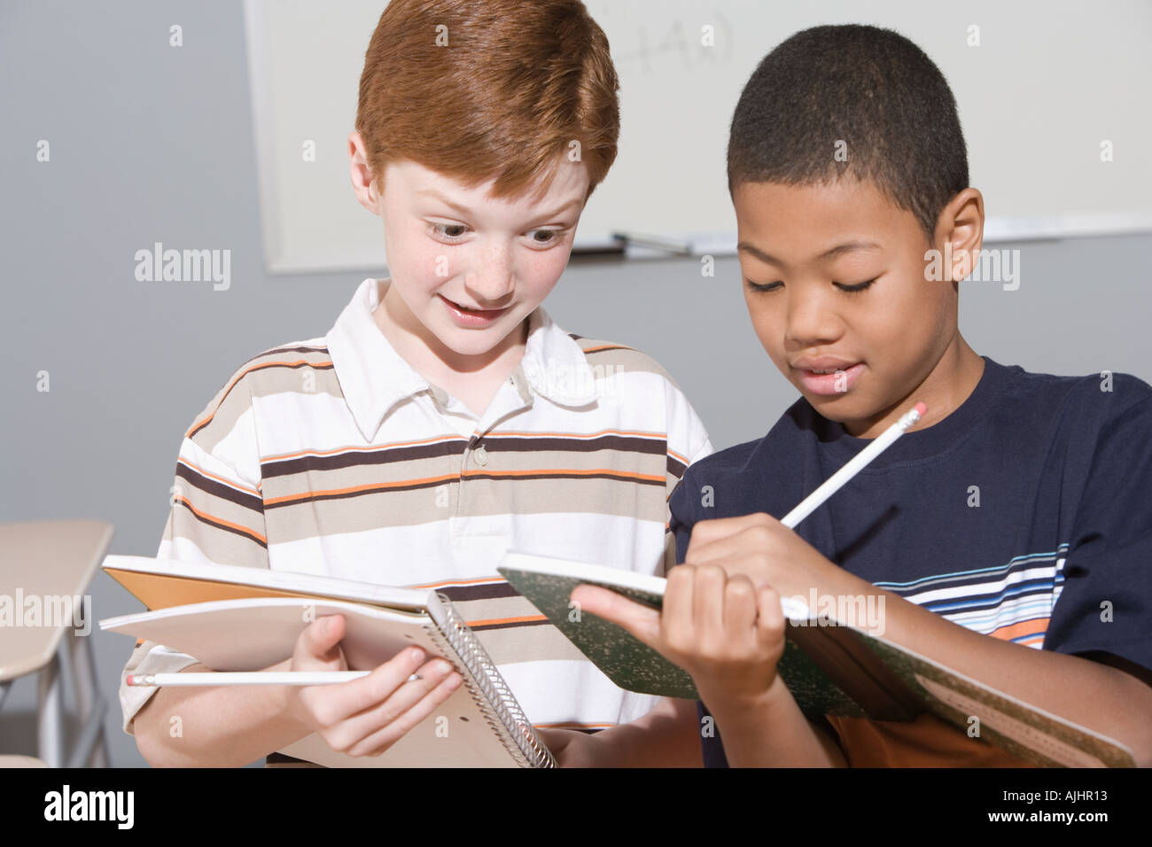 Boys writing in notebooks Stock Photo - Alamy