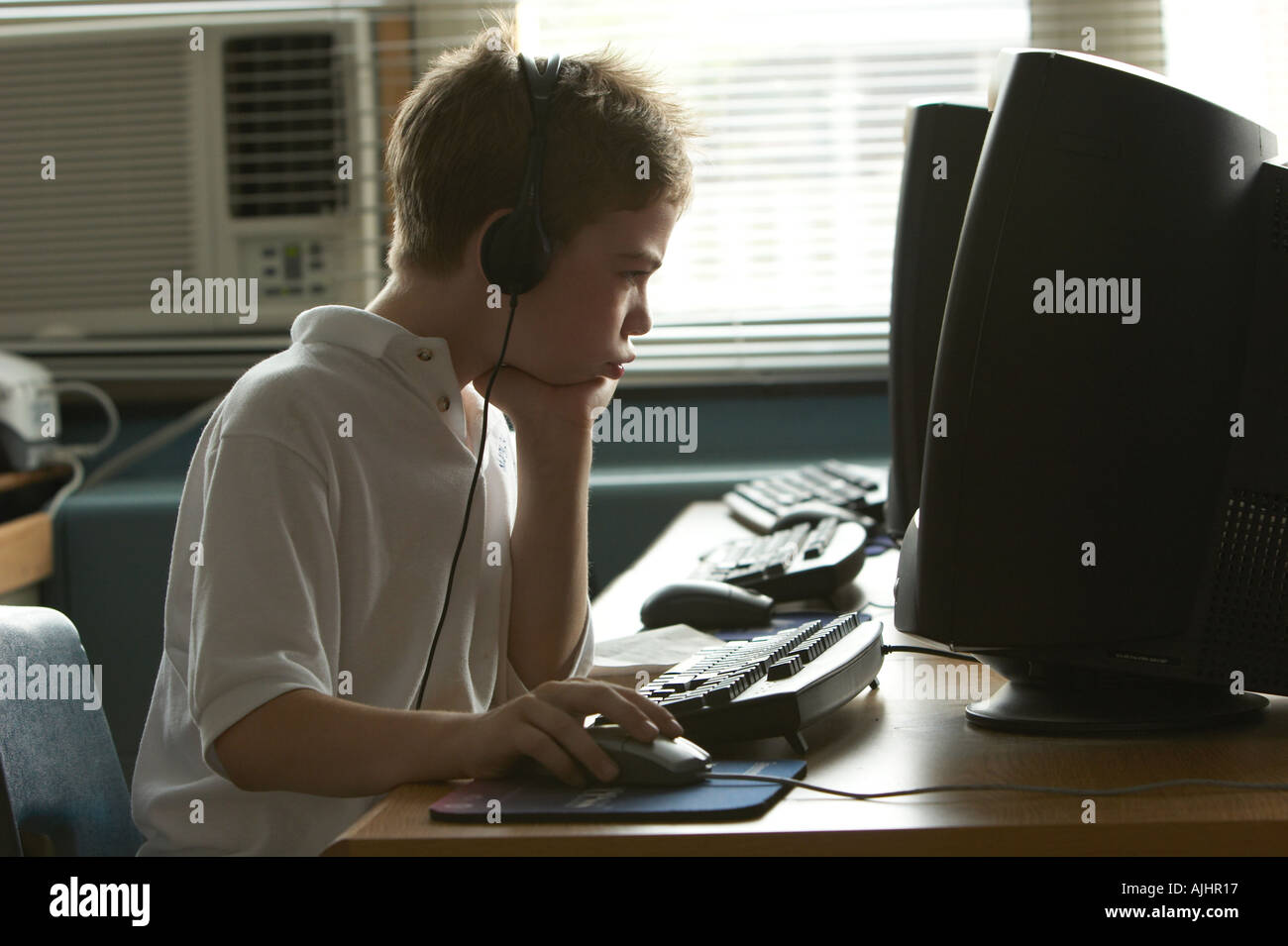 A male student working on a computer in a school computer lab Stock ...