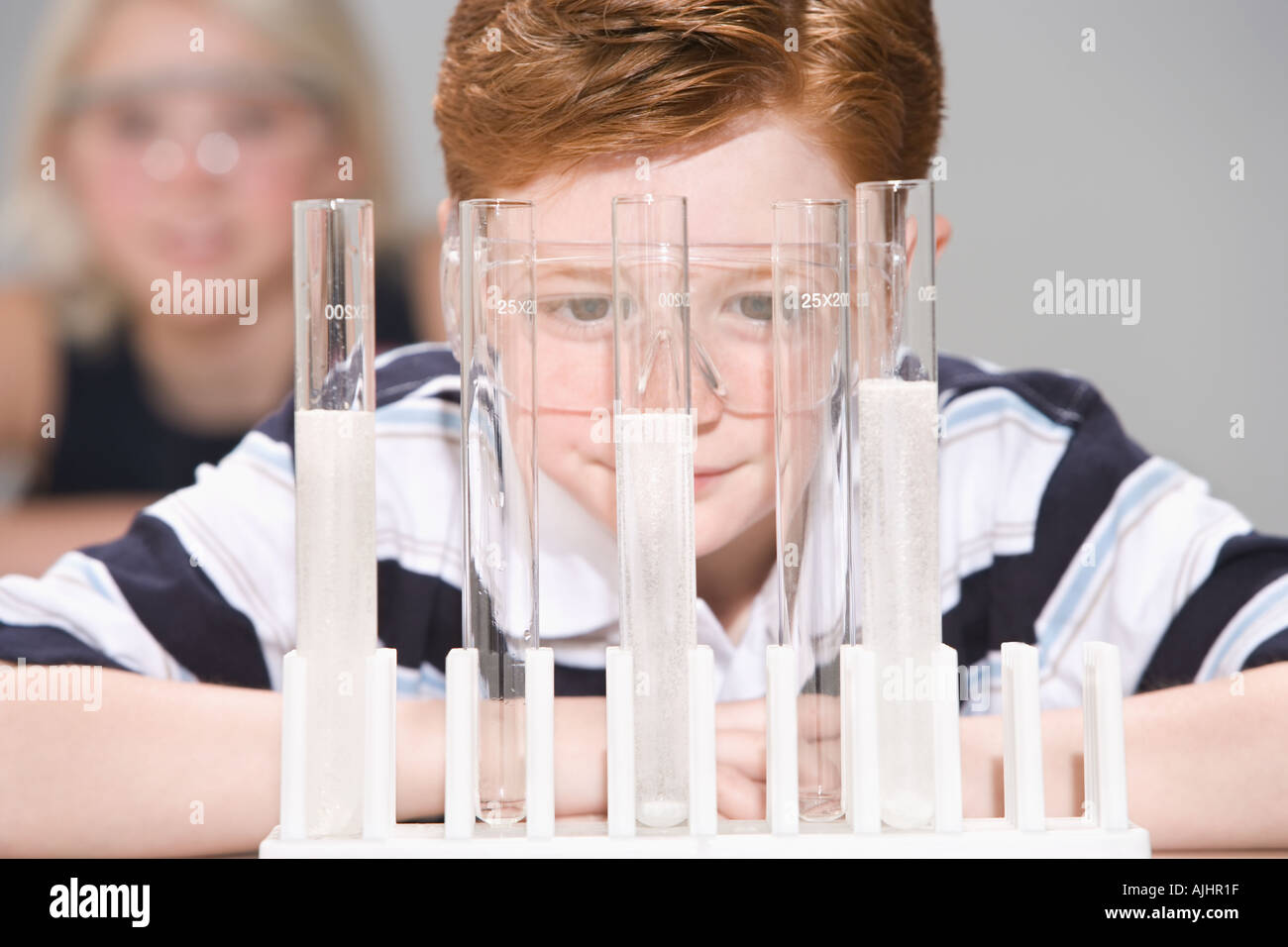 Boy looking at test tubes Stock Photo - Alamy