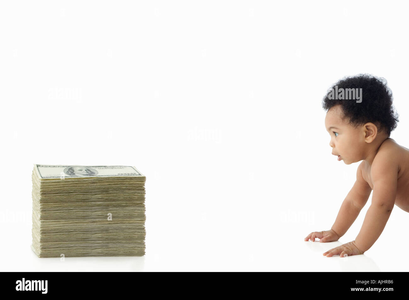 Baby crawling towards pile of money Stock Photo - Alamy