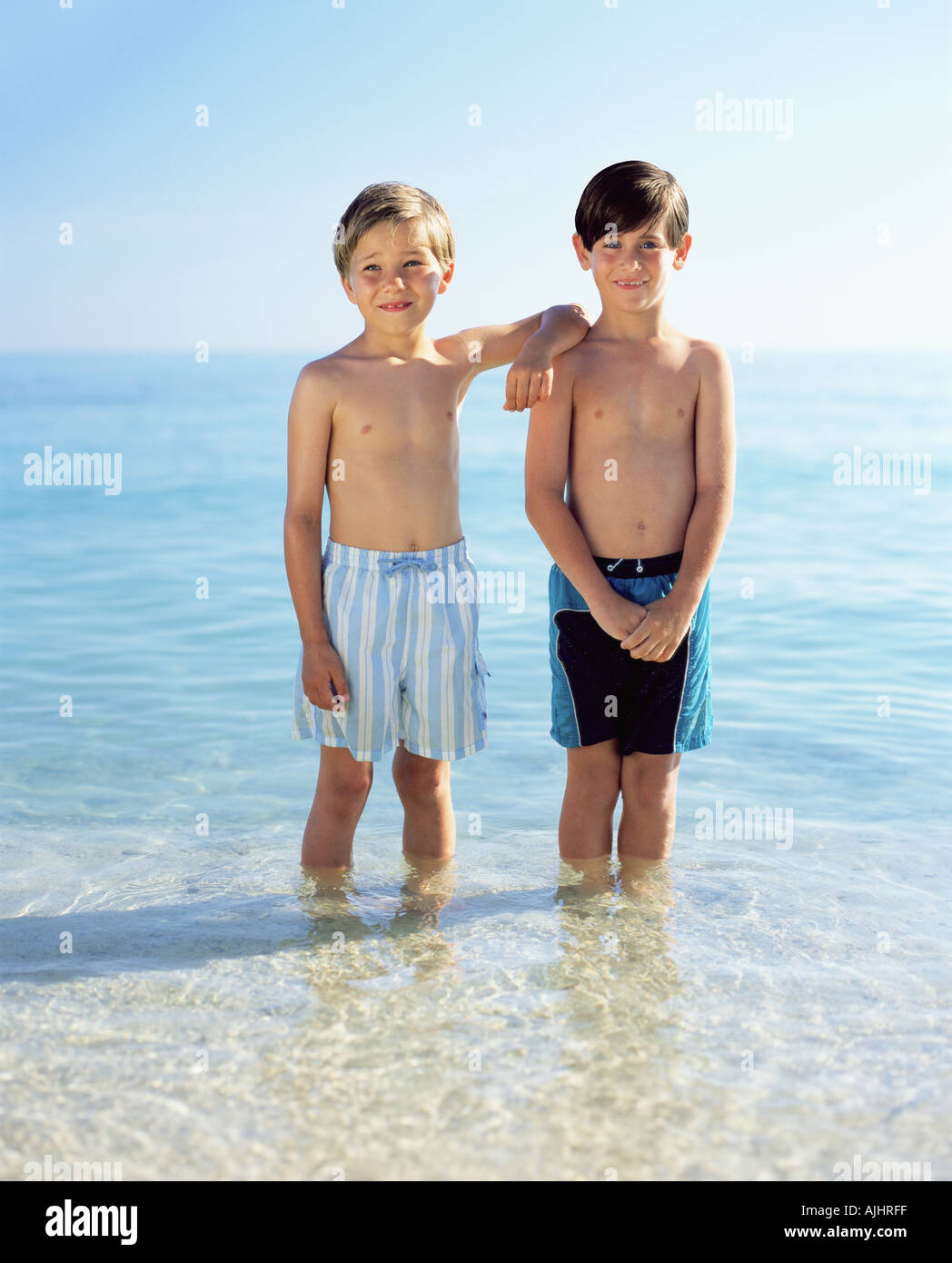 Two boys standing in the sea Stock Photo - Alamy