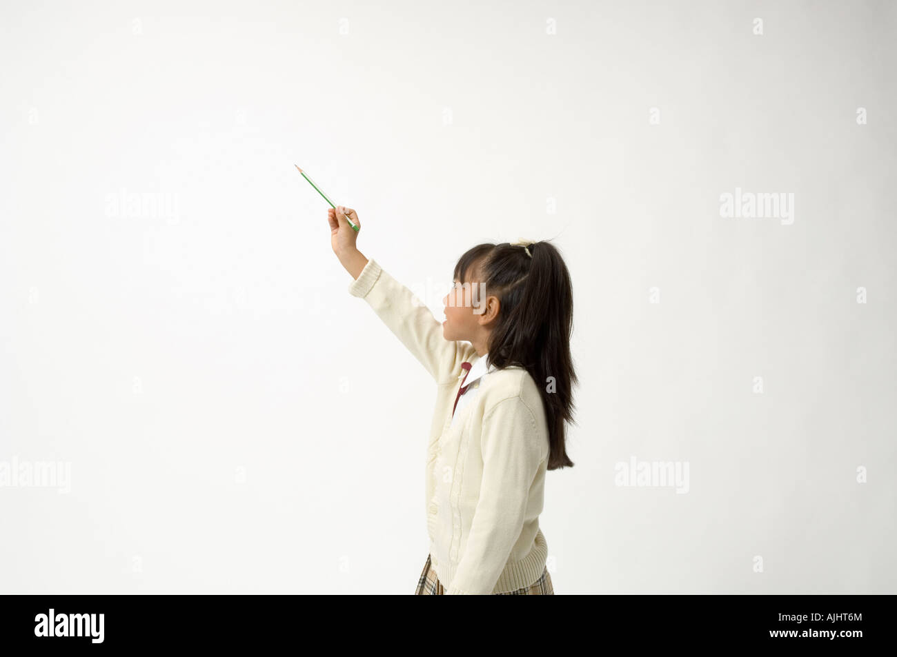 Elementary age girl holding pencil Stock Photo - Alamy
