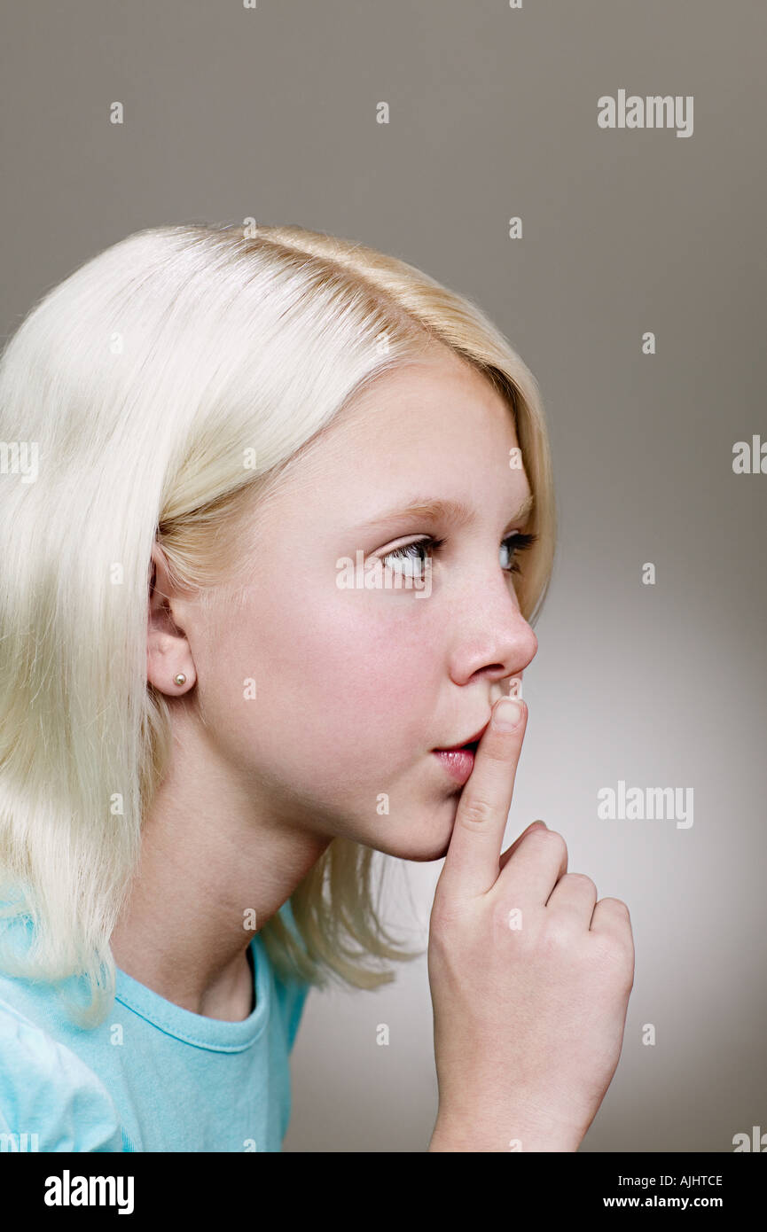 Girl putting finger lips hi-res stock photography and images - Alamy