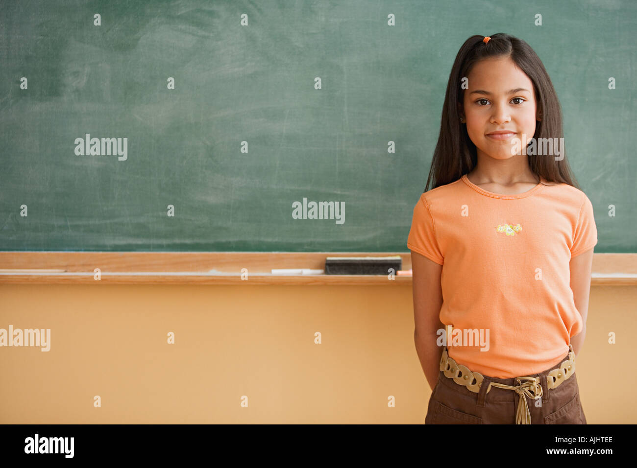 Schoolgirl standing at blackboard Stock Photo - Alamy