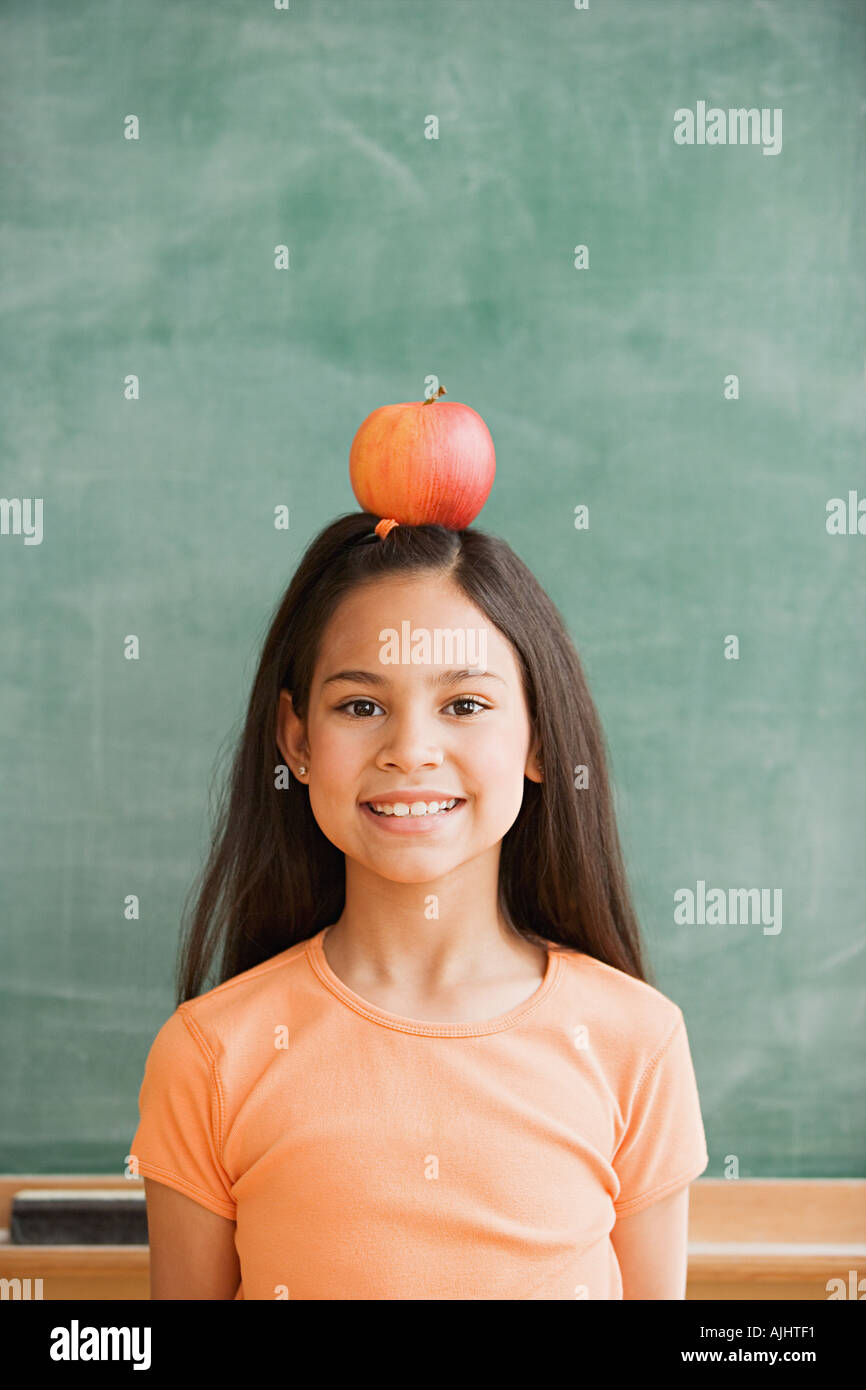 Schoolgirl balancing an apple on her head Stock Photo - Alamy
