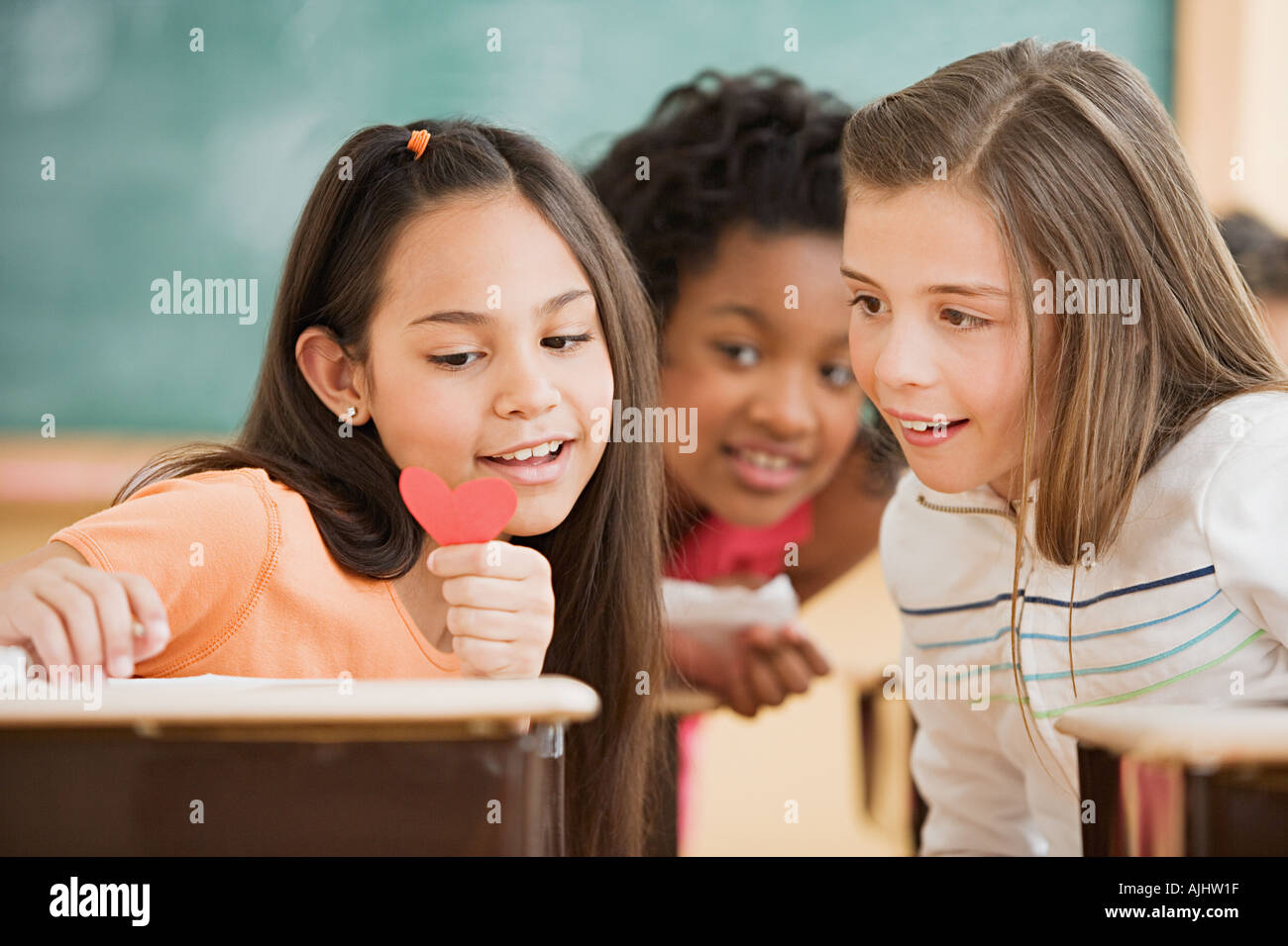 Three girls reading a note Stock Photo - Alamy