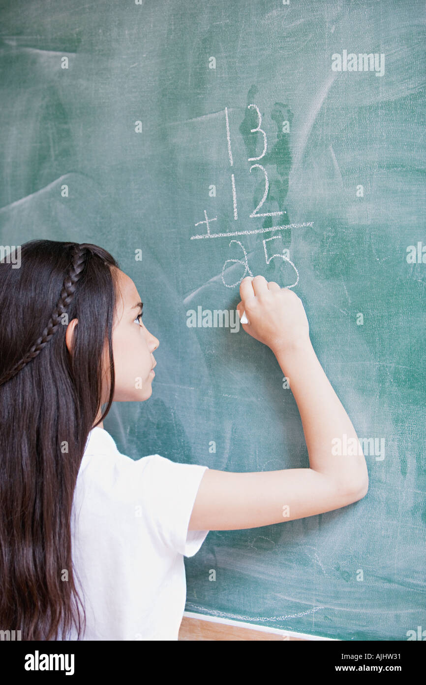 Girl writing a sum on a blackboard Stock Photo - Alamy