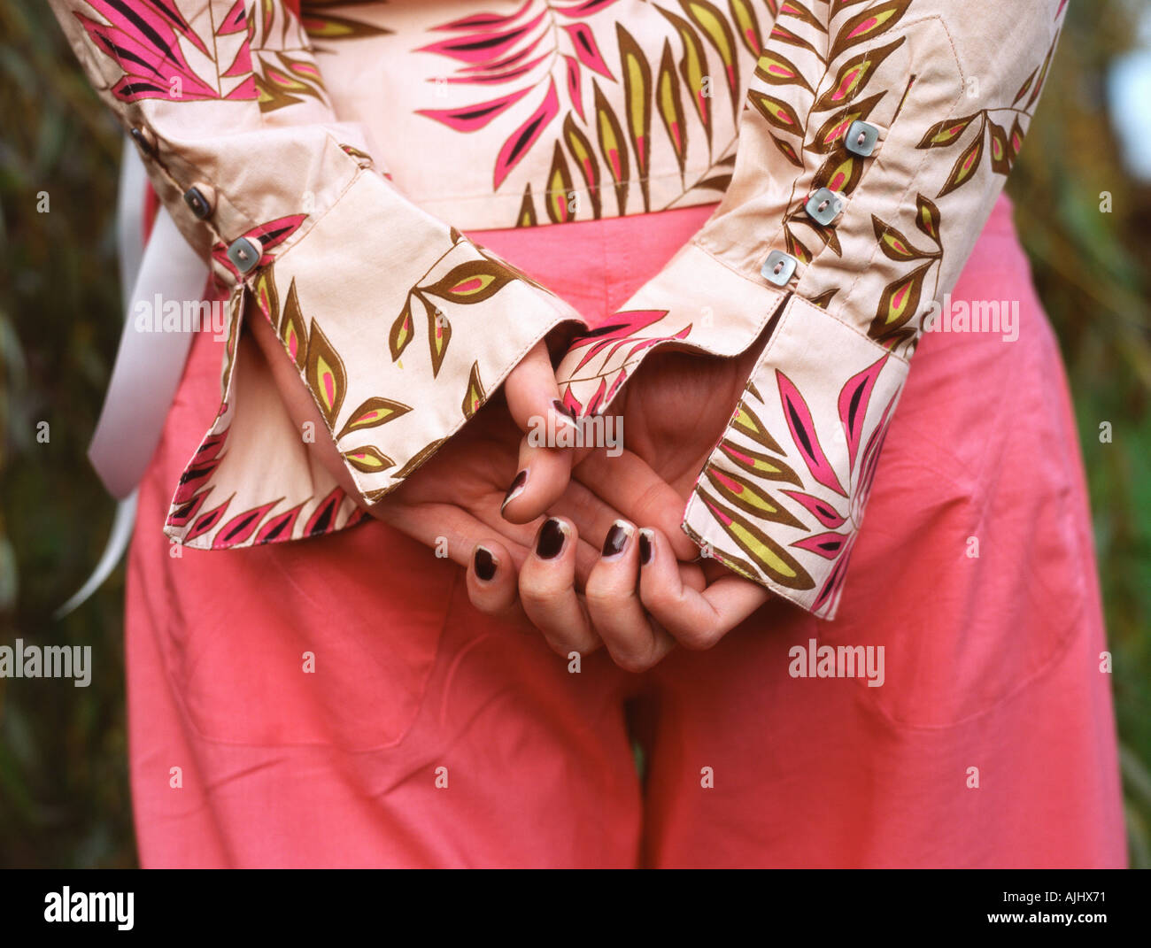Woman with hands behind back Stock Photo - Alamy
