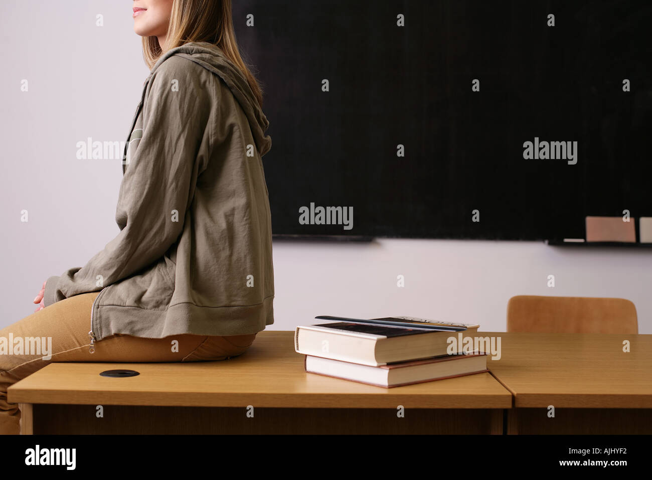 Woman sitting on edge desk hi-res stock photography and images - Alamy