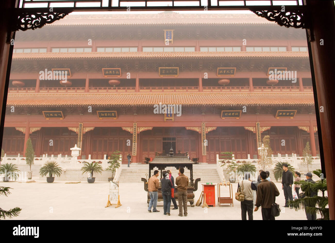 A courtyard pavilion where candles are lit crowded with pilgrims and ...