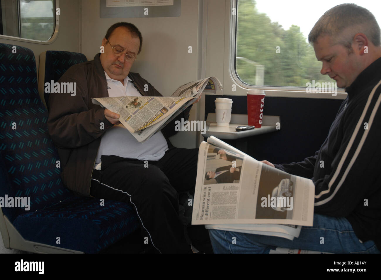 Brighton to London train Two passengers reading newspapers Stock Photo ...