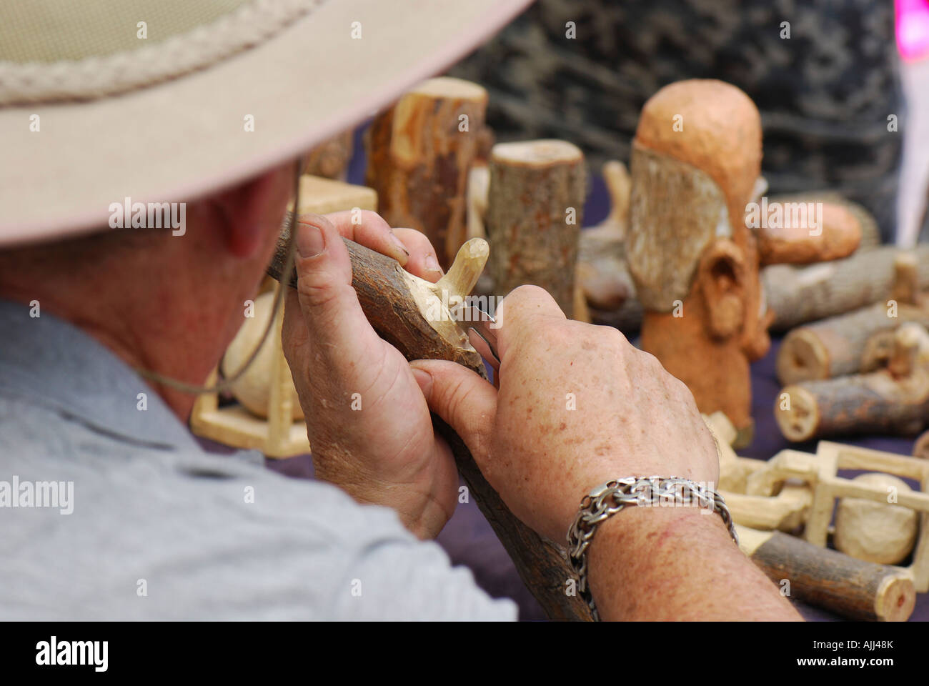 A man hand carving wood as seen from over his shoulder Stock Photo - Alamy