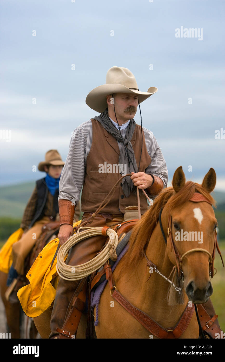 Cowboy hats riding horses vertical hi-res stock photography and images ...