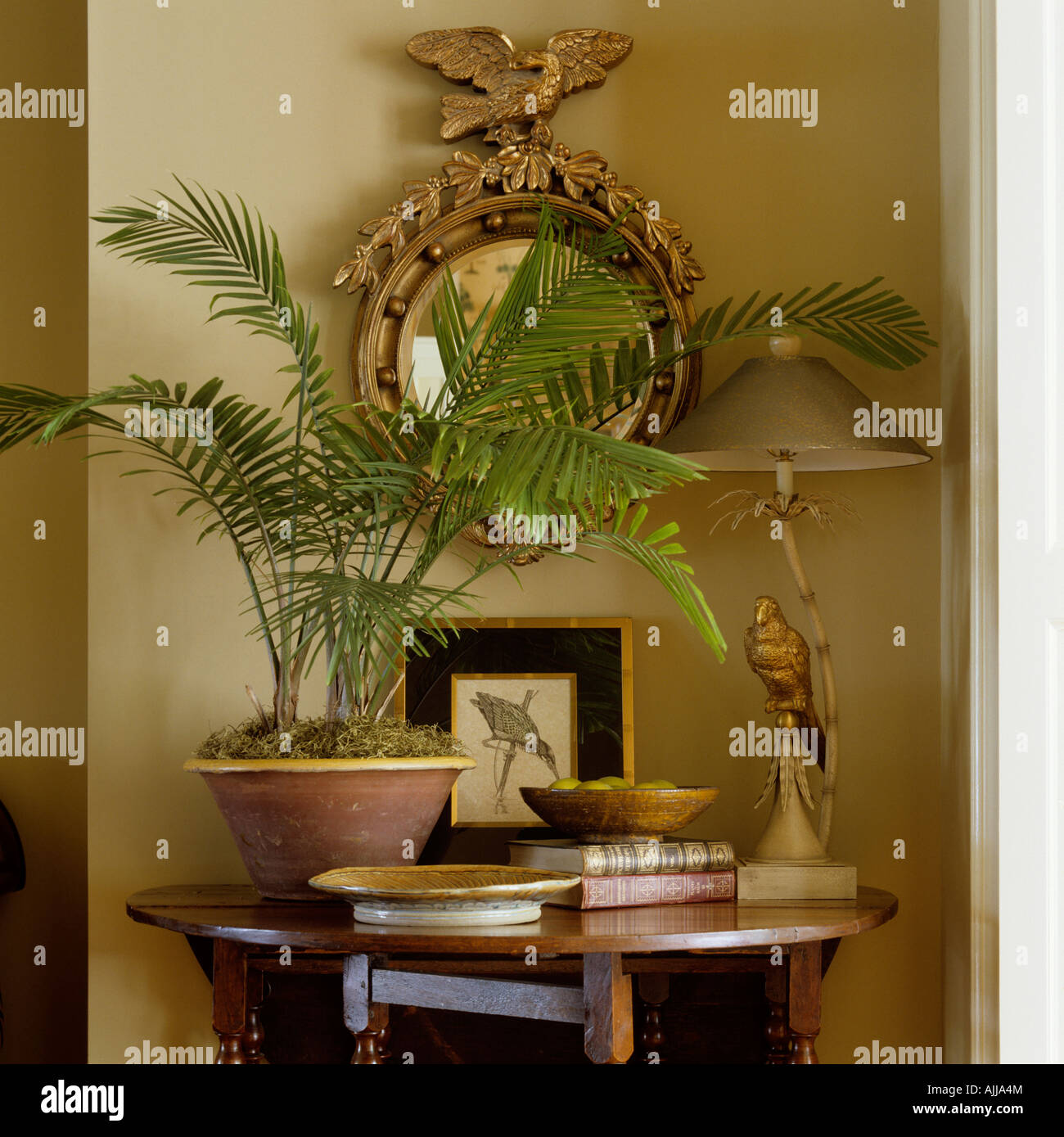 Hall table with pot plant and gild bullseye mirror with eagle Stock ...