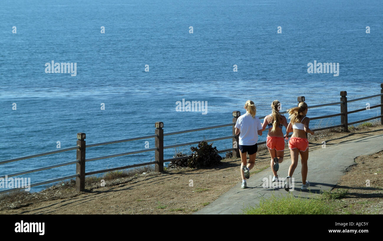 Young Women Running on Coastal Path to the edge of the Pacific Ocean at ...