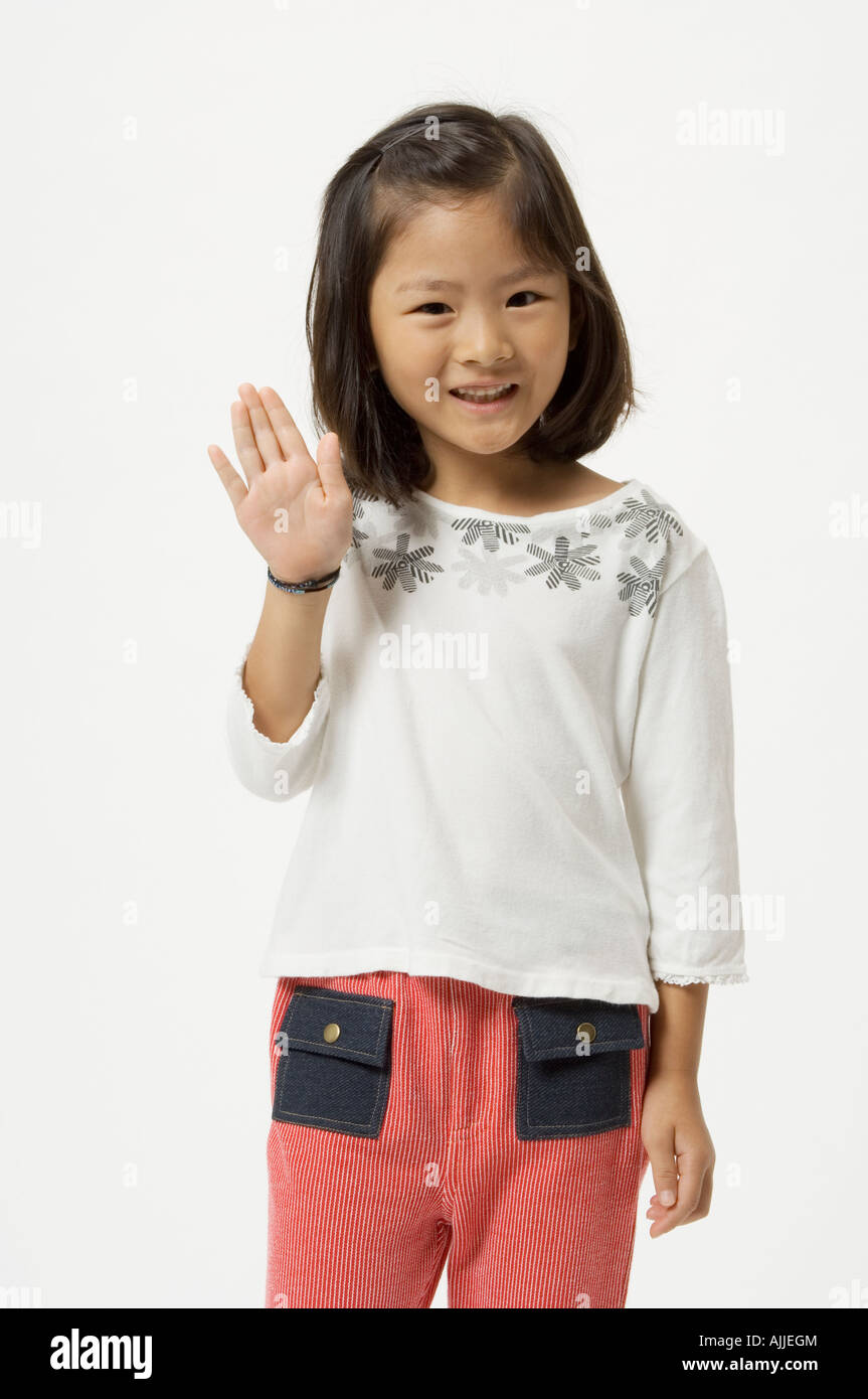 Elementary age girl waving Stock Photo - Alamy