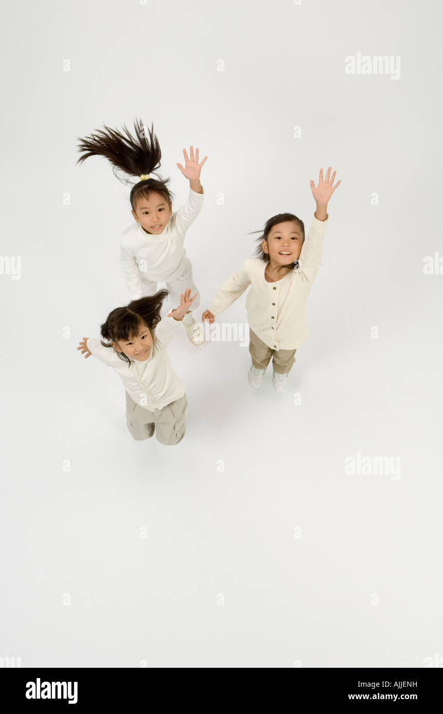 Three elementary age girls jumping Stock Photo - Alamy