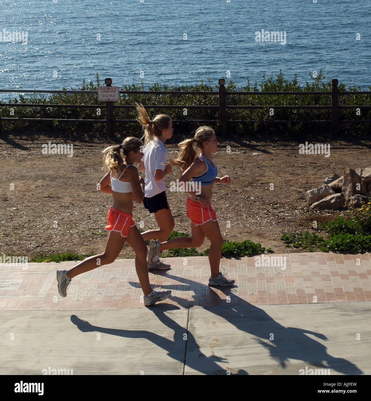 Young Women Running on Coastal Path to the edge of the Pacific Ocean at ...