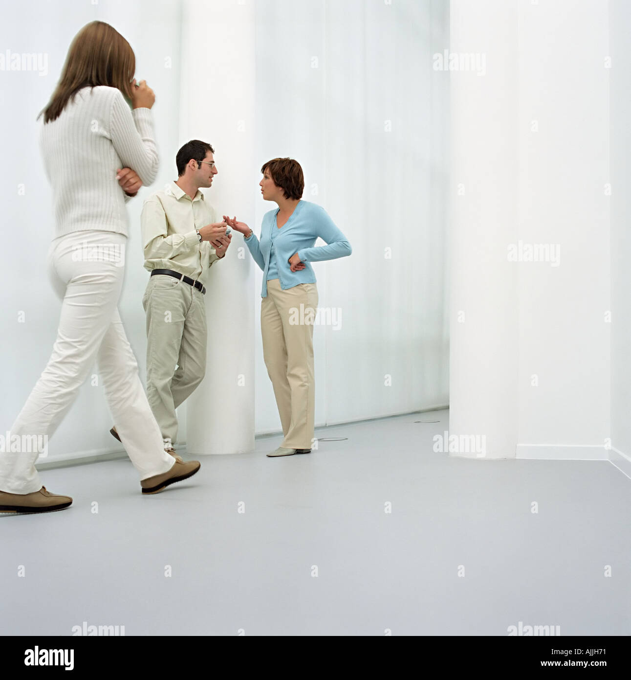 Office workers talking in corridor Stock Photo - Alamy