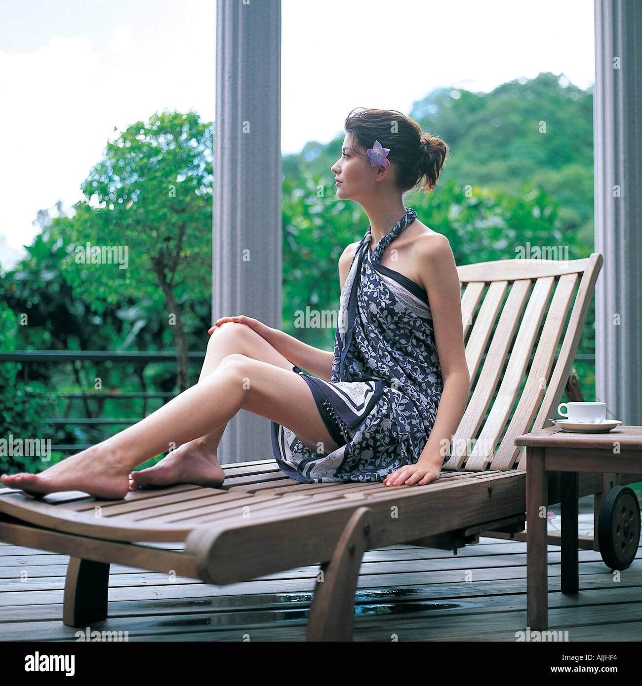 Side profile of a young woman sitting on a lounge chair Stock Photo - Alamy
