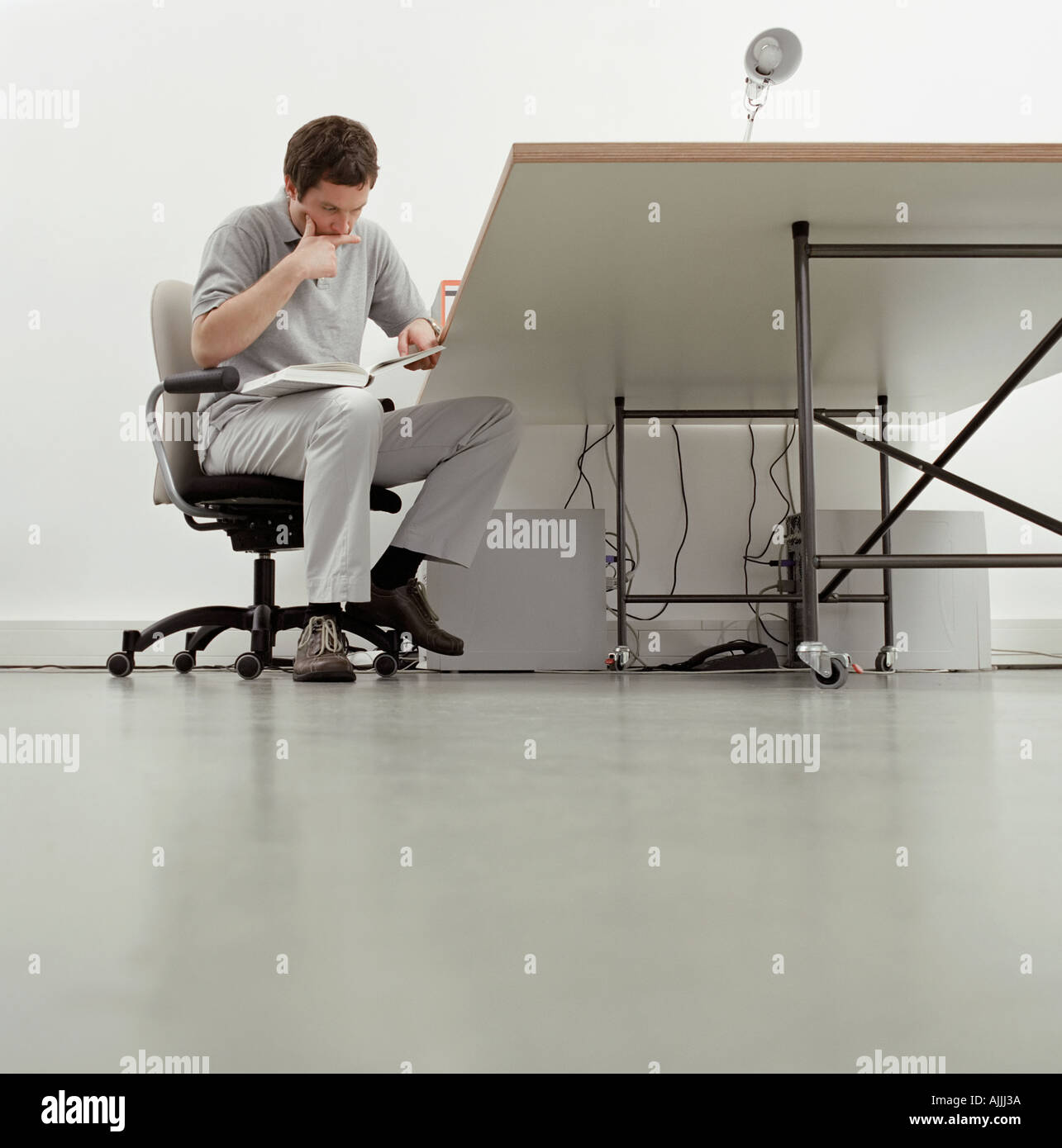 Office worker reading a book Stock Photo - Alamy