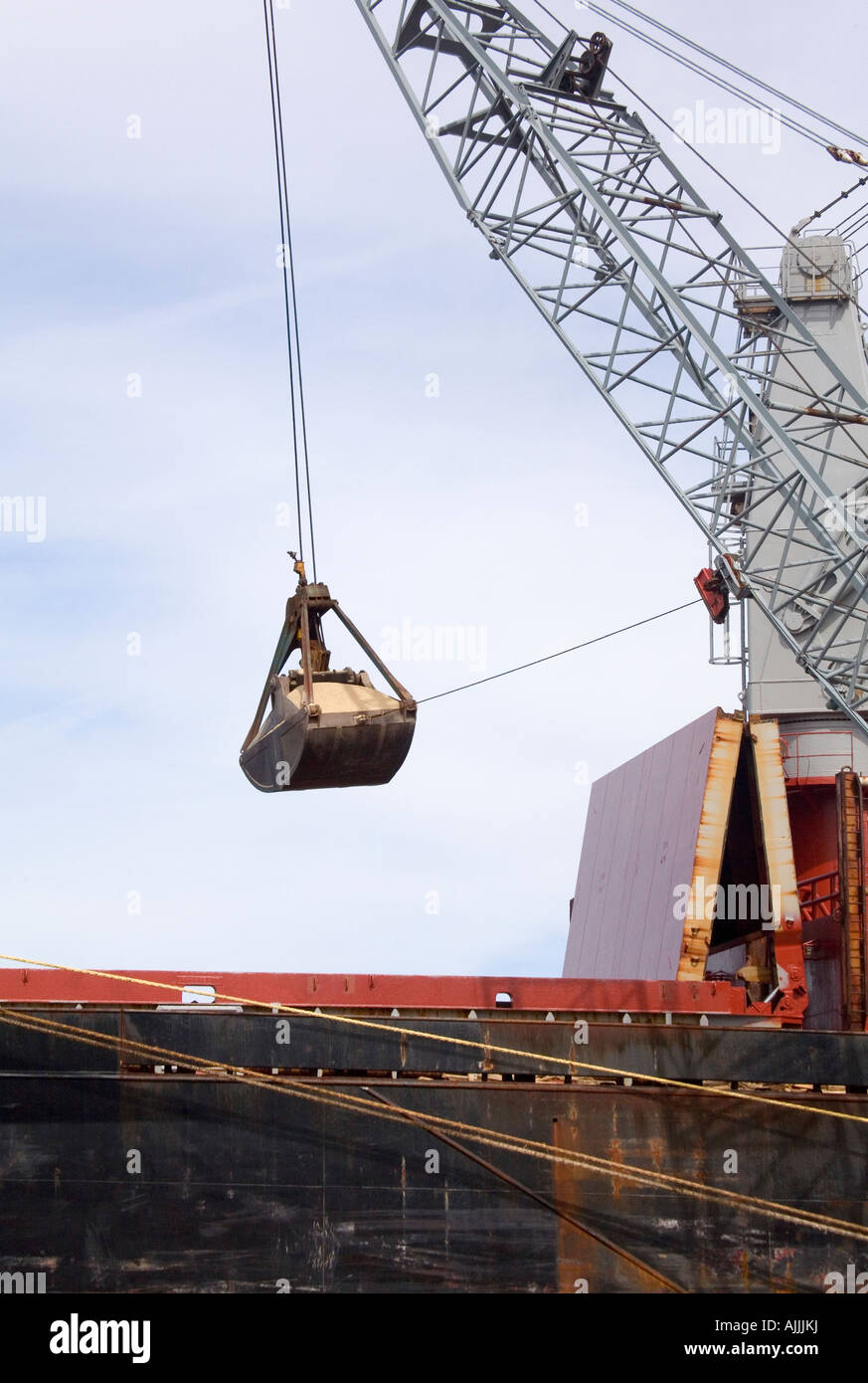 A clamshell bucketloader is seen about to dump a load of sand after ...
