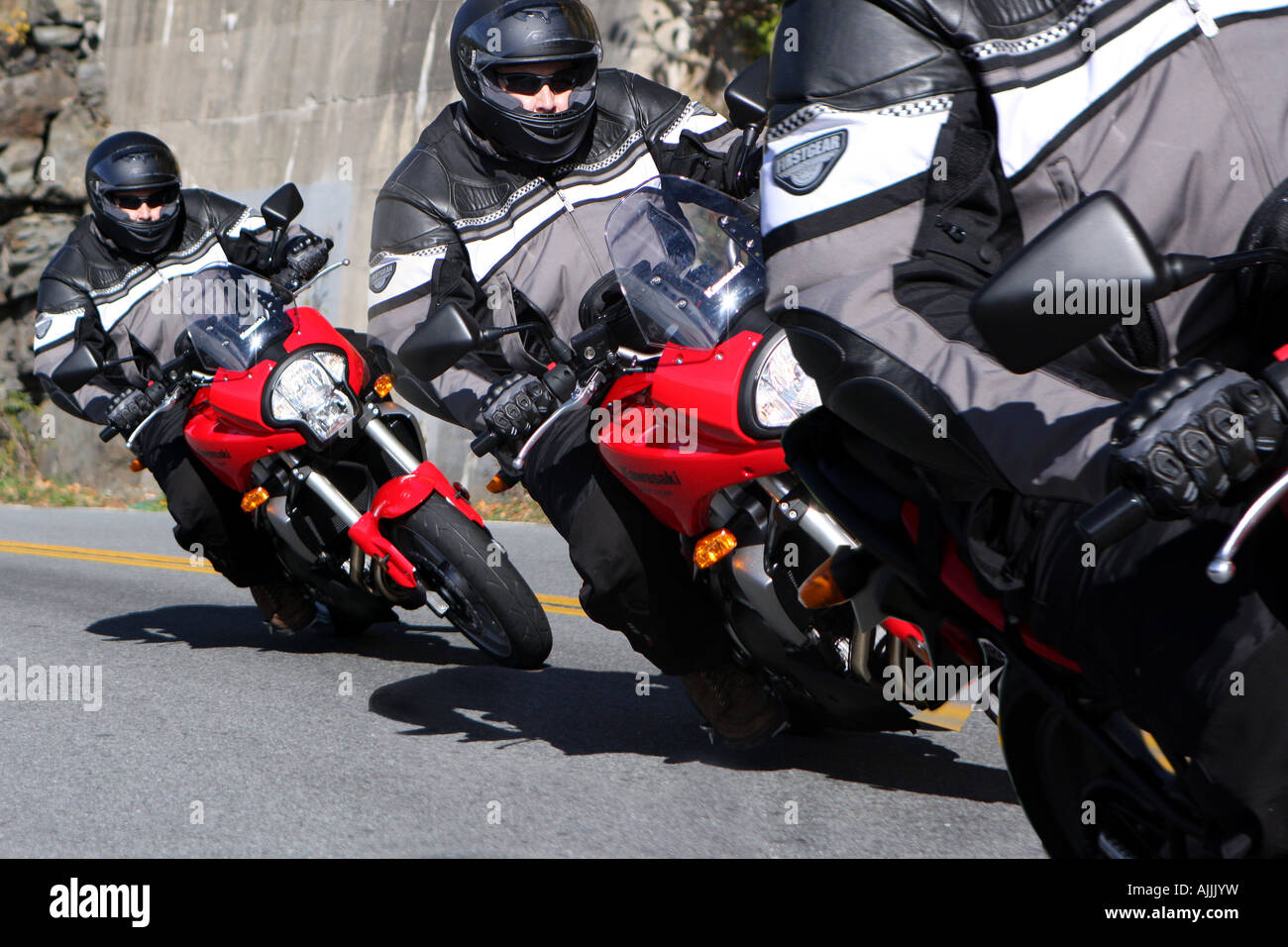 Three shots in progression of a very red motorcycle in a turn at speed ...