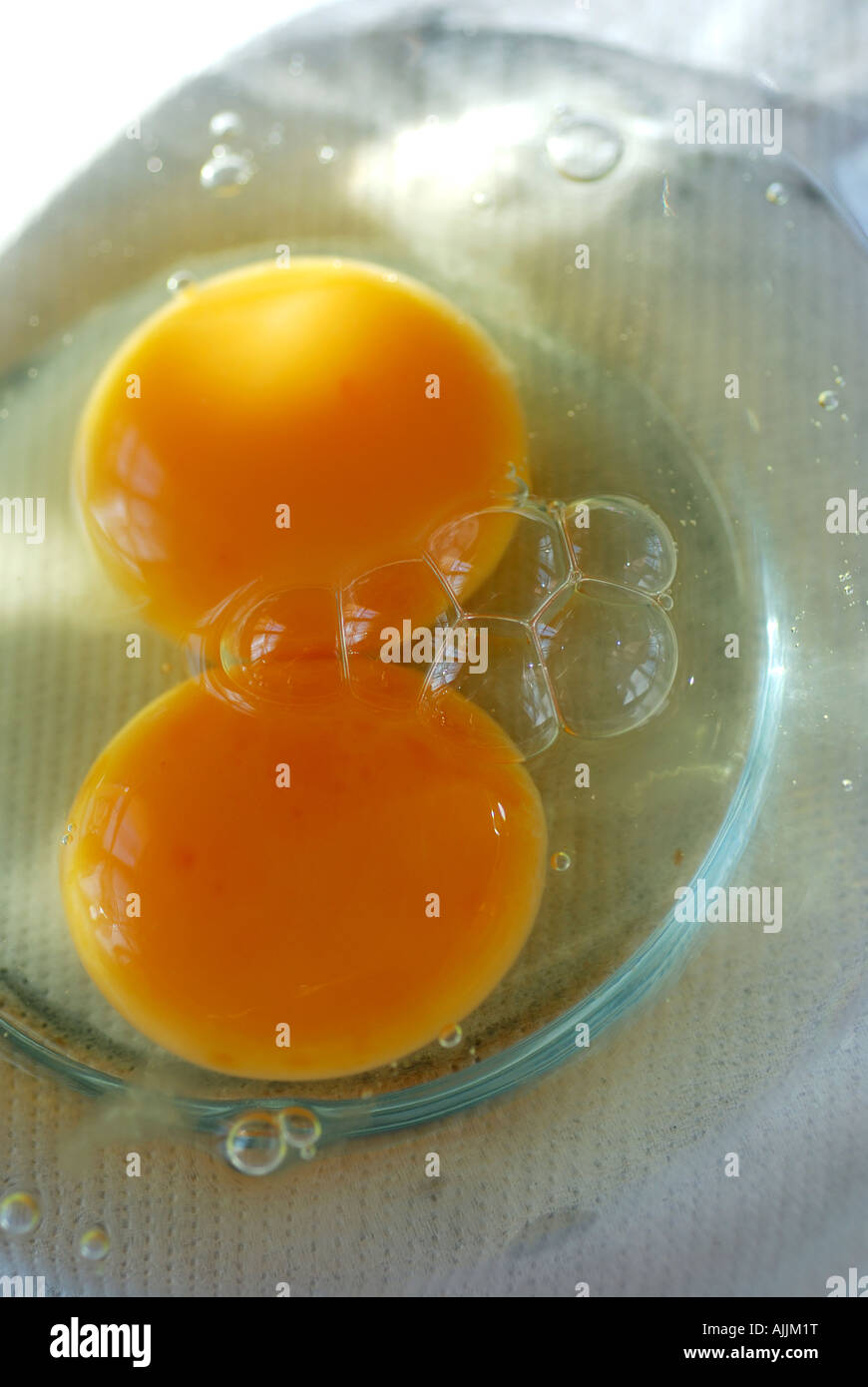 TWO RAW CRACKED CHICKEN EGGS IN GLASS BOWL READY FOR BEATING Stock Photo - Alamy