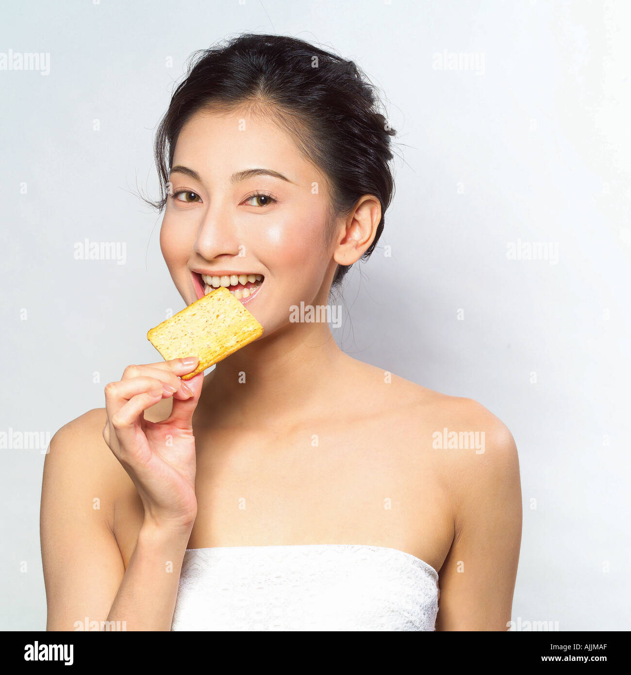 Woman eating a cracker smiling hi-res stock photography and images - Alamy