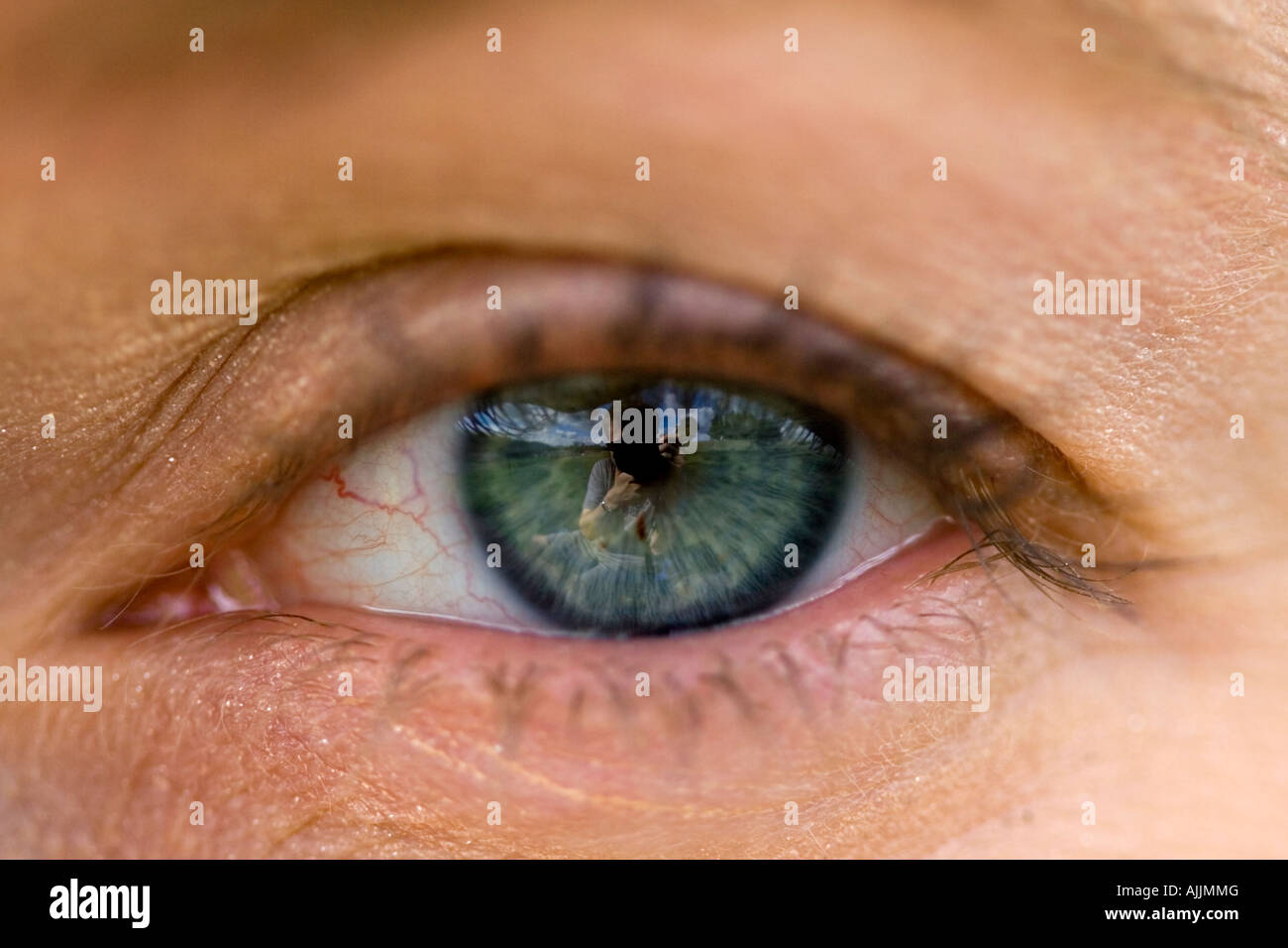 Closeup of woman's eyeball with reflection of sky and photographer ...