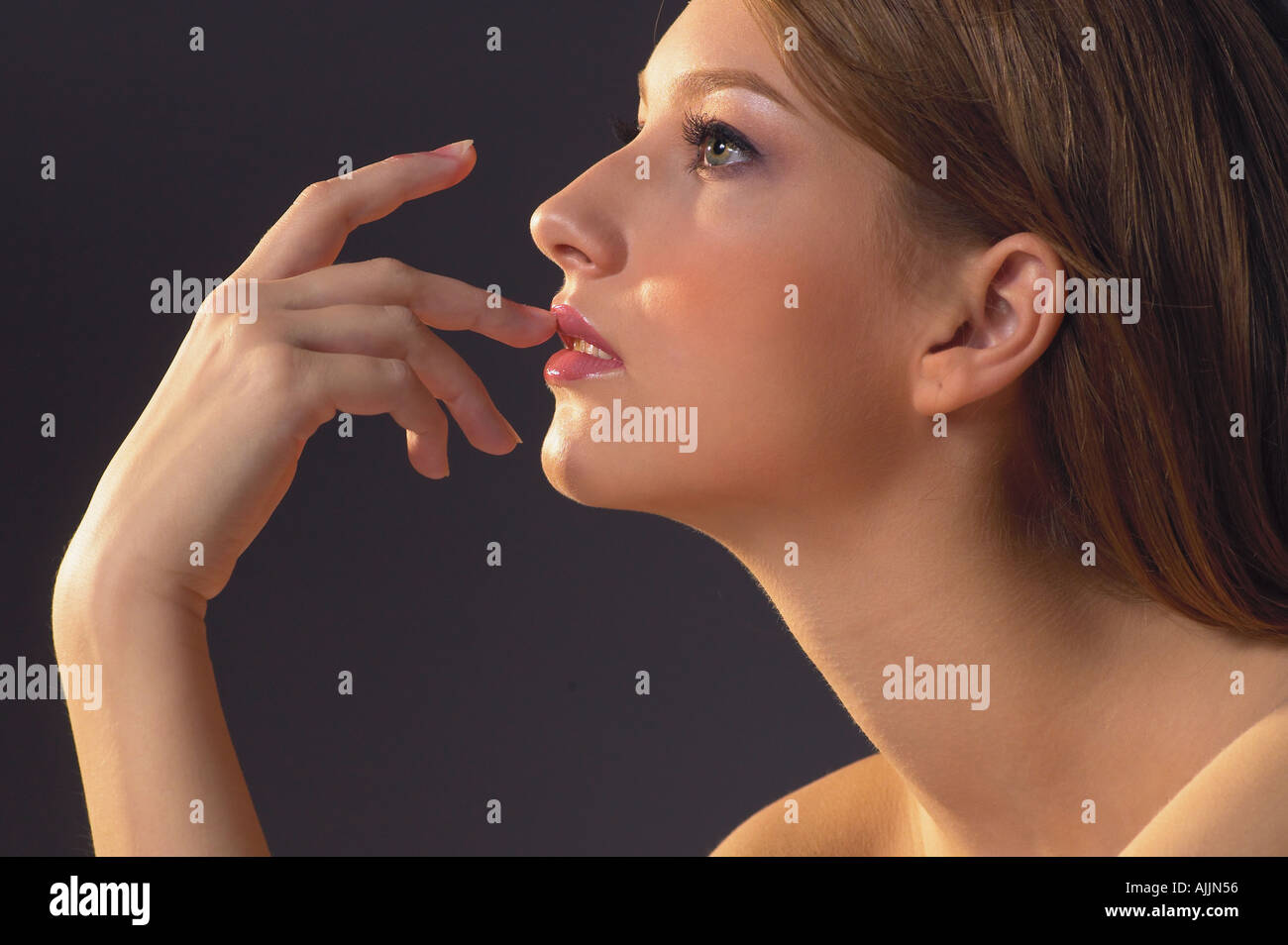 Side profile of a young woman touching her lip Stock Photo - Alamy