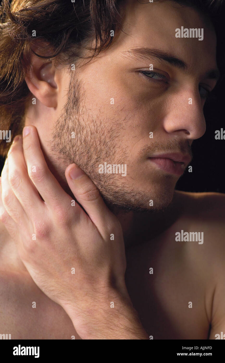 Close up of a young man with his hand on his neck Stock Photo - Alamy