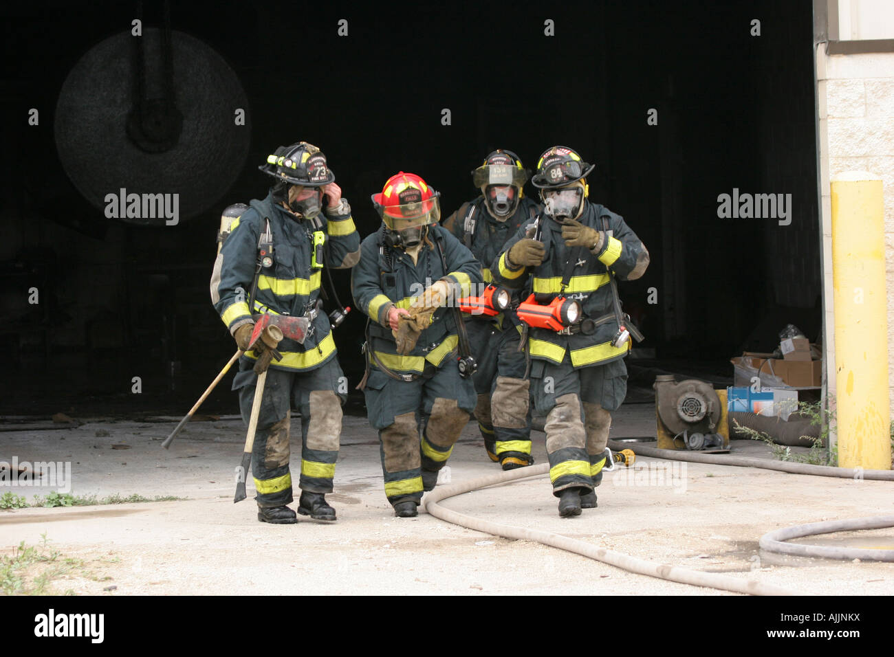 Fire Fighters exiting a fire scene inside a building Stock Photo - Alamy