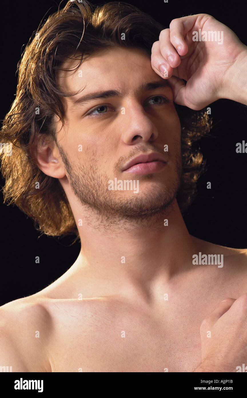 Low angle view of a young man touching his forehead Stock Photo - Alamy