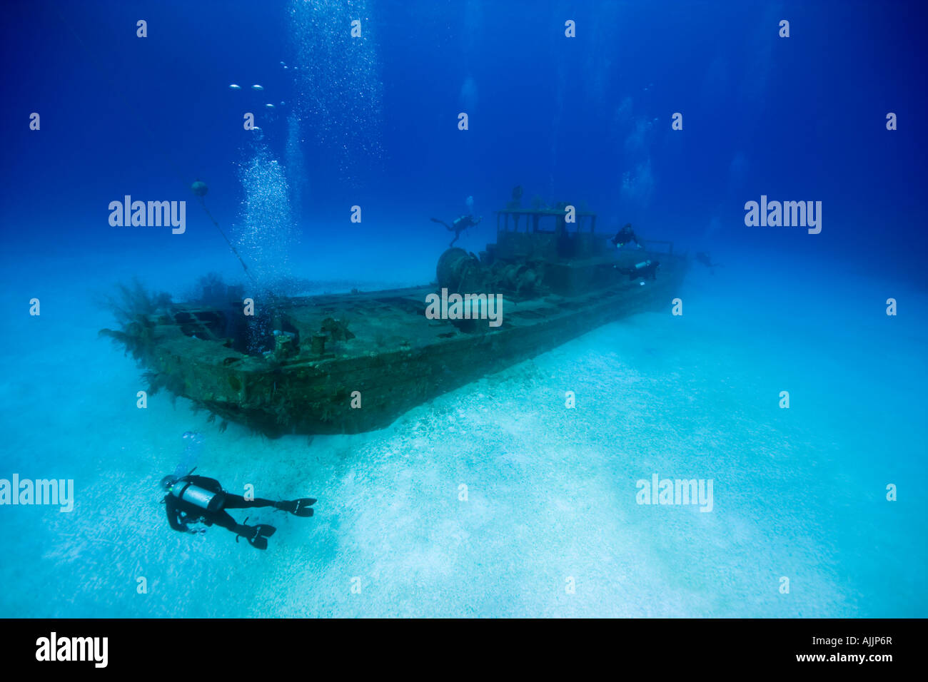 Scuba divers explore underwater sunken barge shipwreck Doc Poulson in ...