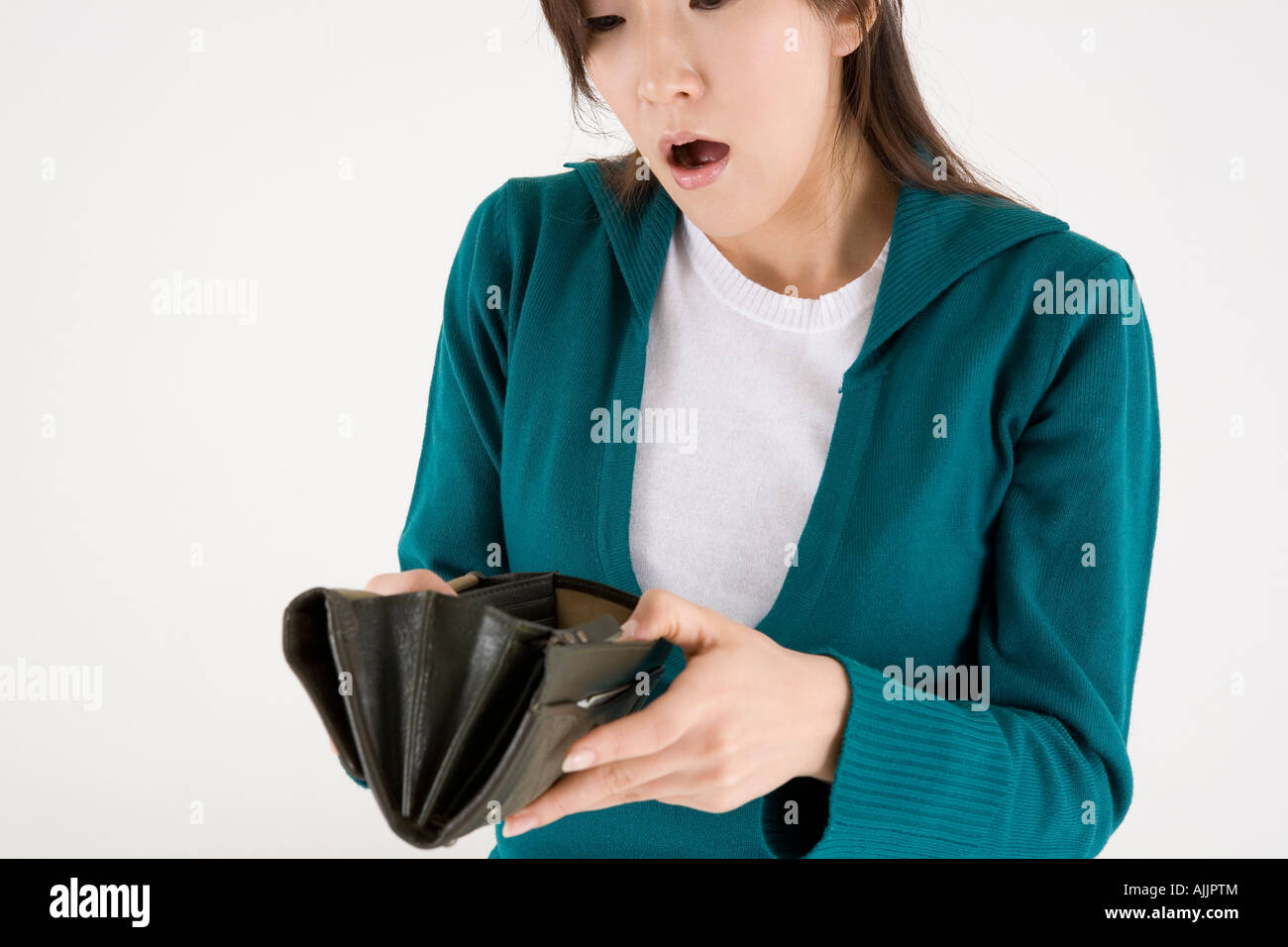 Young woman looking into empty wallet Stock Photo - Alamy